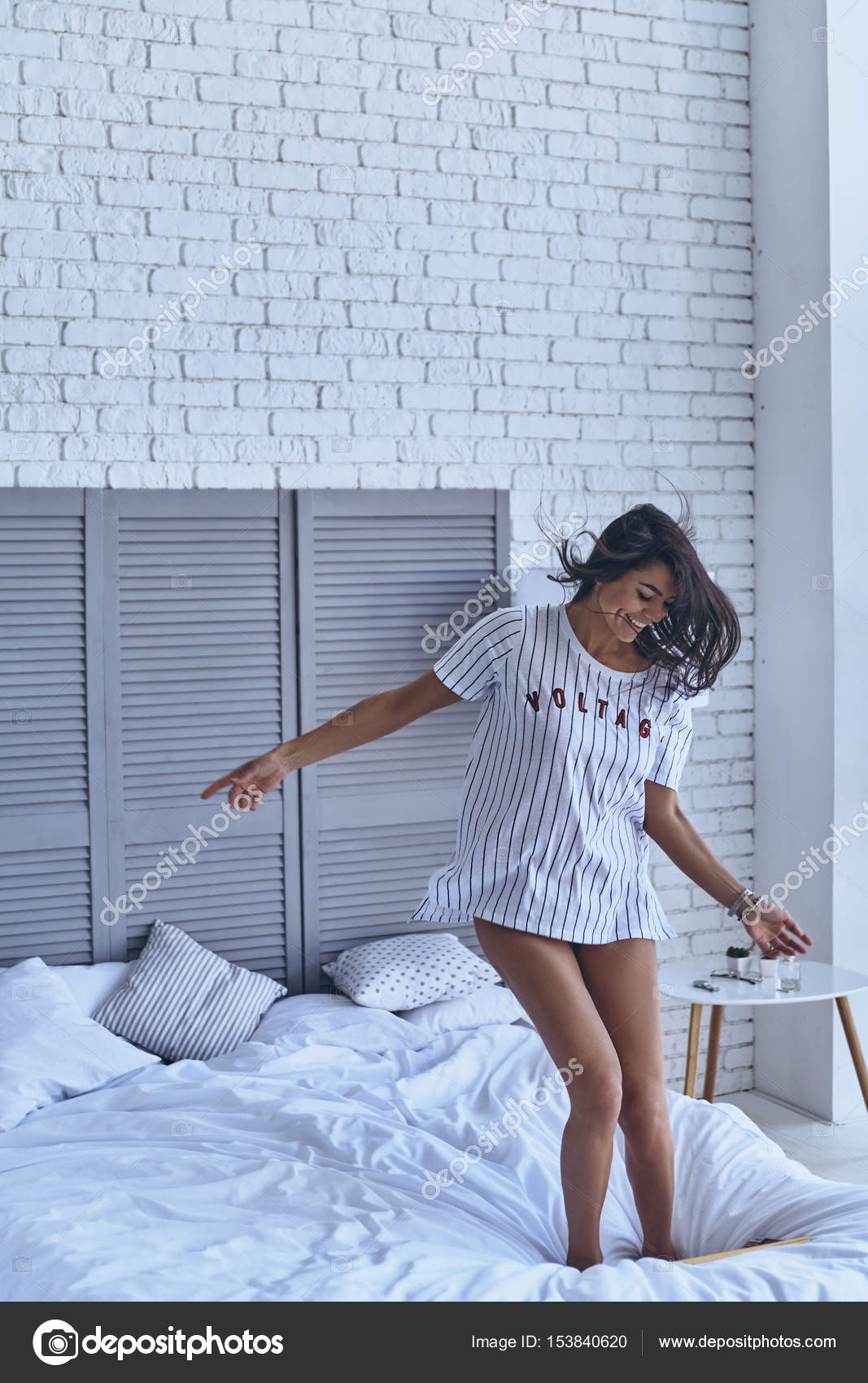 Woman jumping on bed Stock Photo by ©gstockstudio 153840620