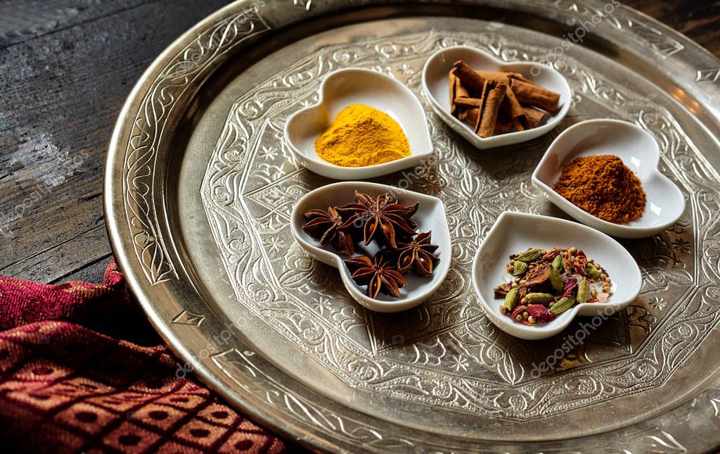 Cinco bandejas en forma de corazón con anís estrellado y curry en polvo ...