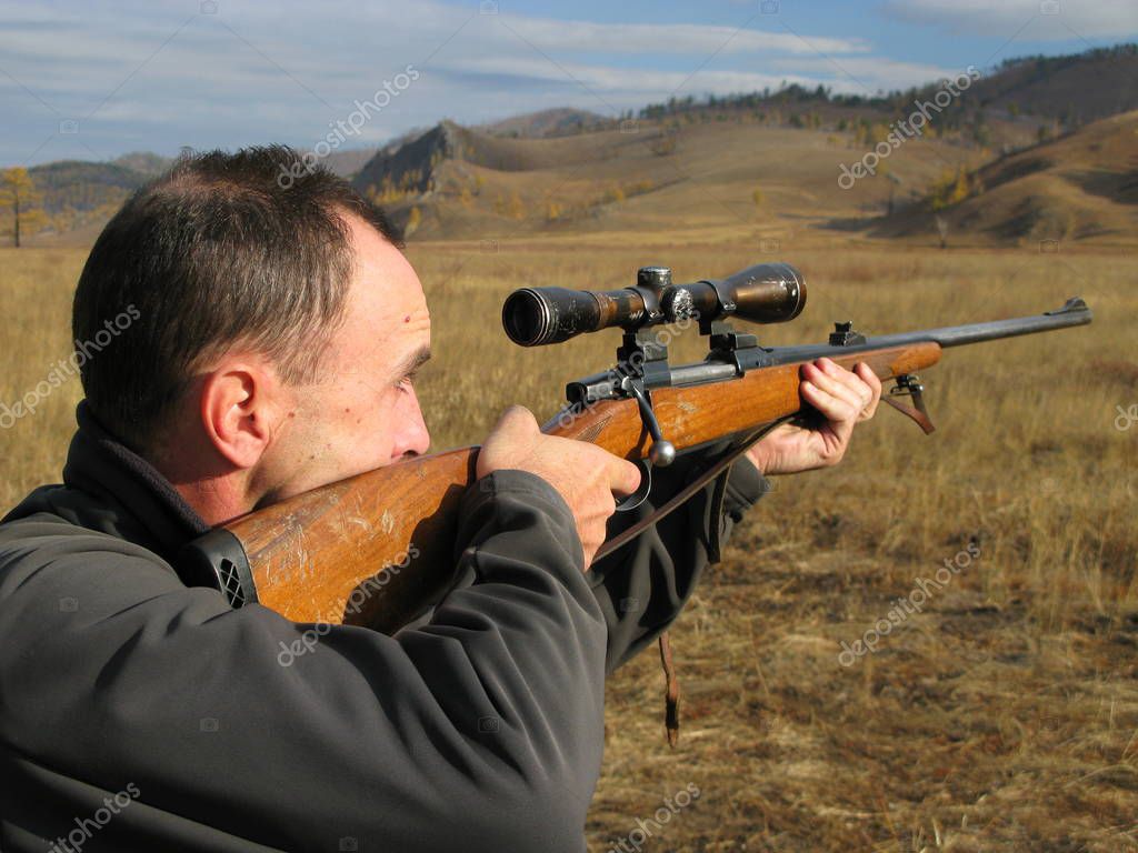 cazador con fusil en las montañas 2024