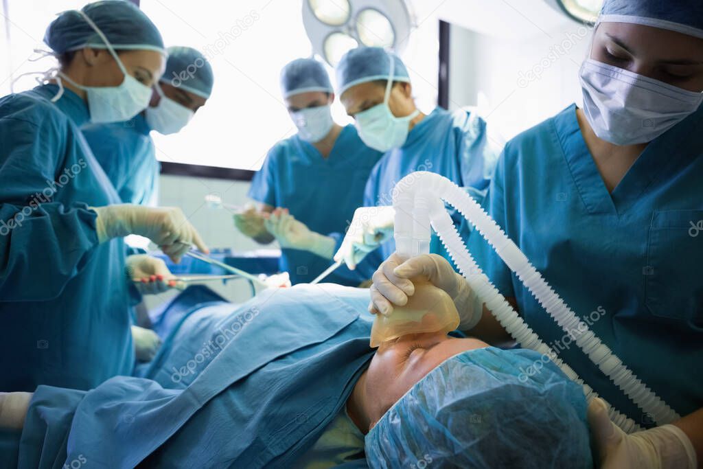 Paciente inconsciente siendo operado por cirujanos en un quirófano 2023