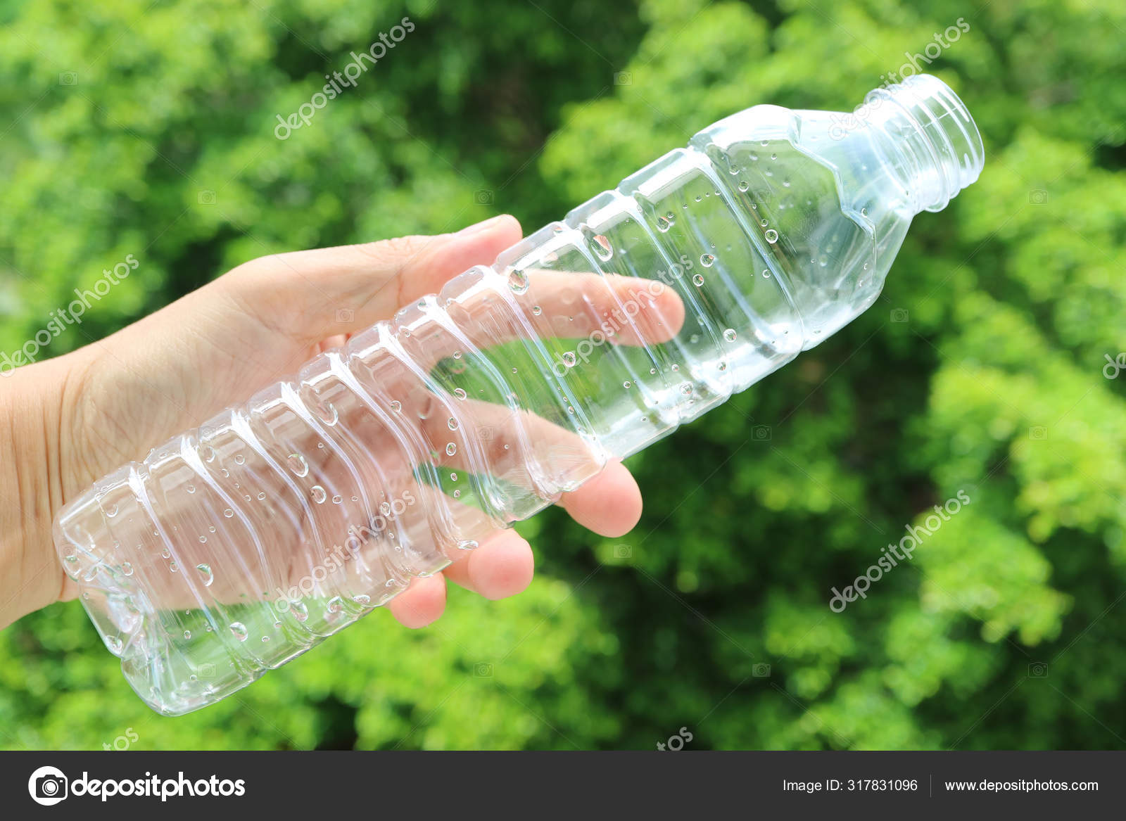 Man's Hand Holding Empty Plastic Bottle Drinking Water Blurry Green ...