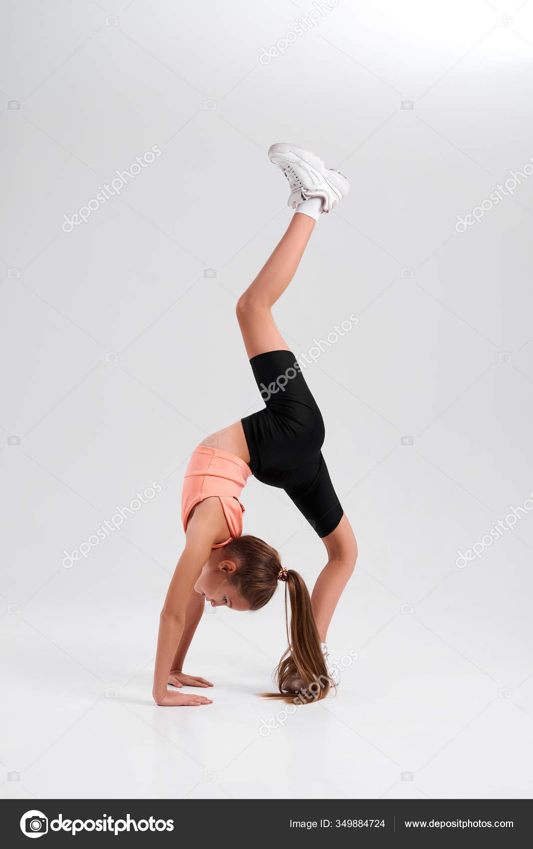 Energize your life. Flexible cute little girl child bending over ...