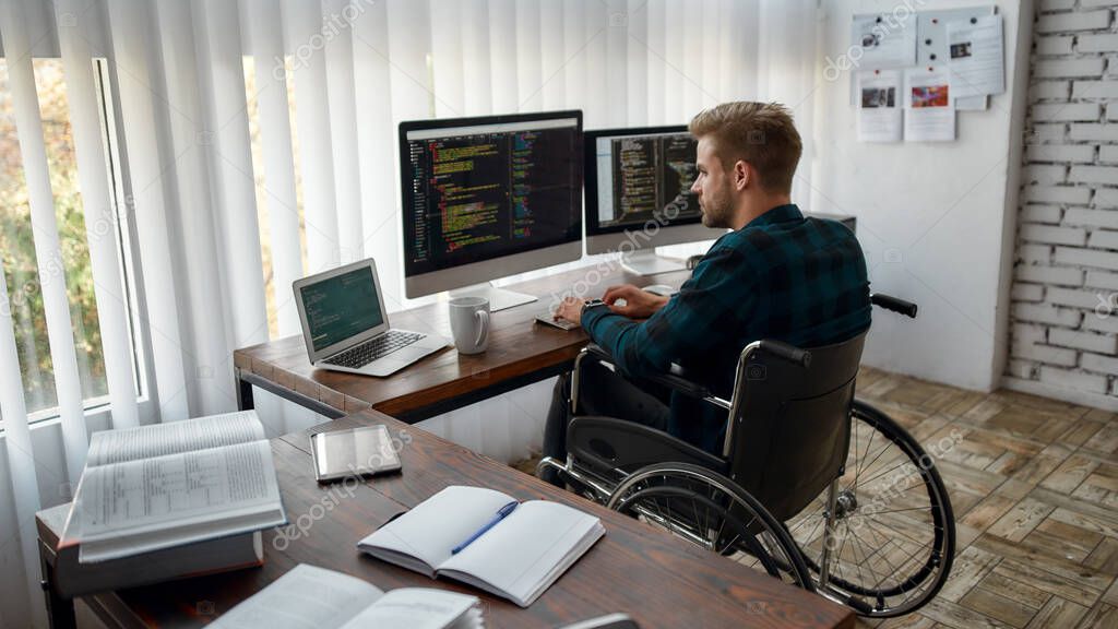 Concentración total. Vista posterior de un joven desarrollador web profesional en una silla de ...