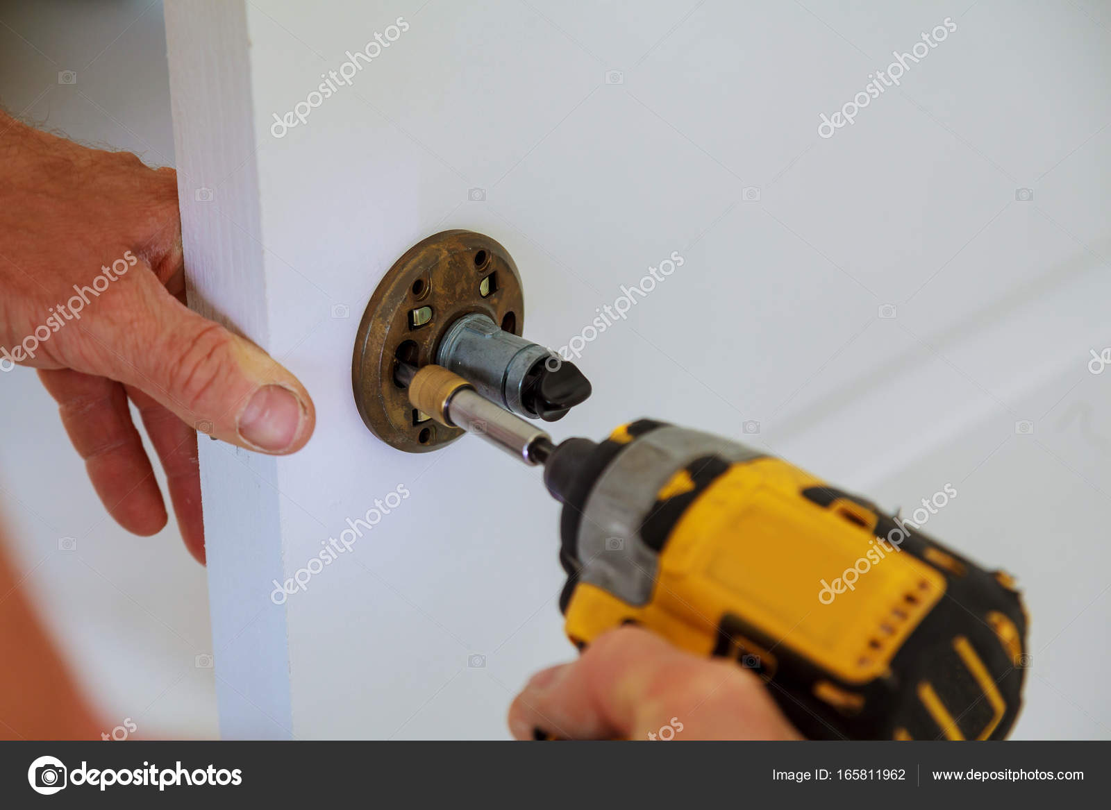 Installation of door lock using a screwdriver to. Carpenter at lock ...