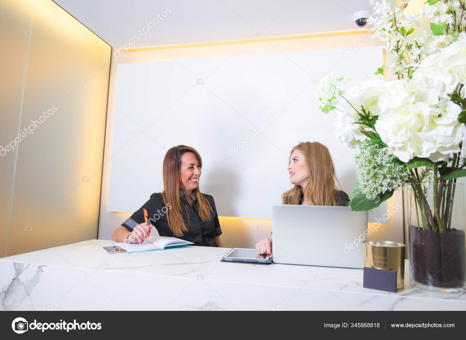 Two Young Female Receptionists Uniform Talking Laughing While Working ...