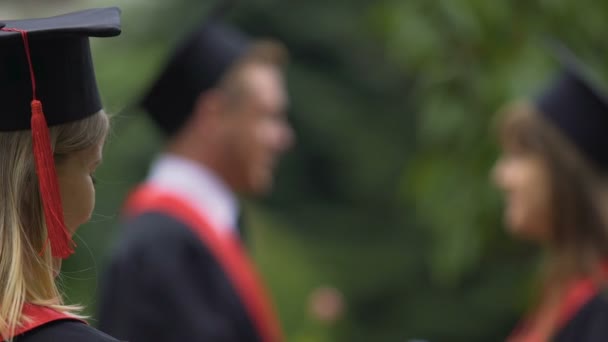 Happy pair of graduate students dancing and fooling around, holding ...