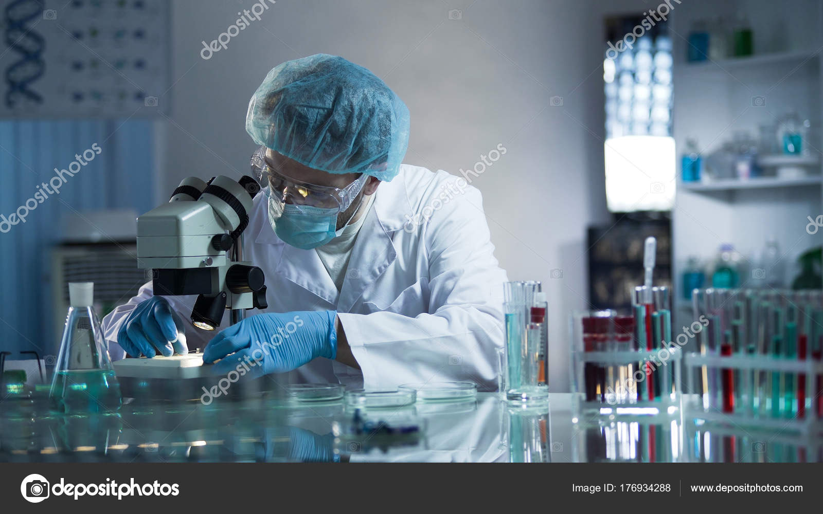 Medical lab worker examining laboratory glass with sample through ...