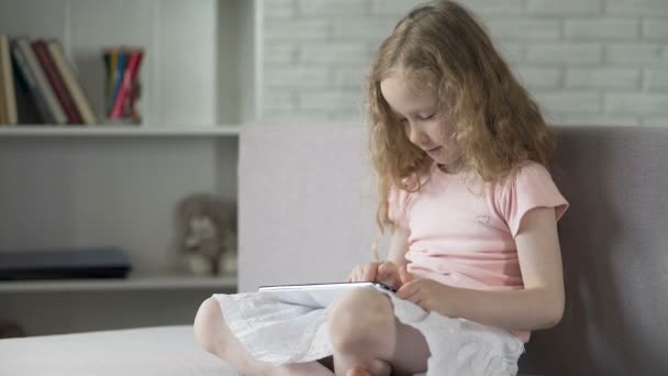 Cute little kid learning easily with interactive mobile app on gadget ...