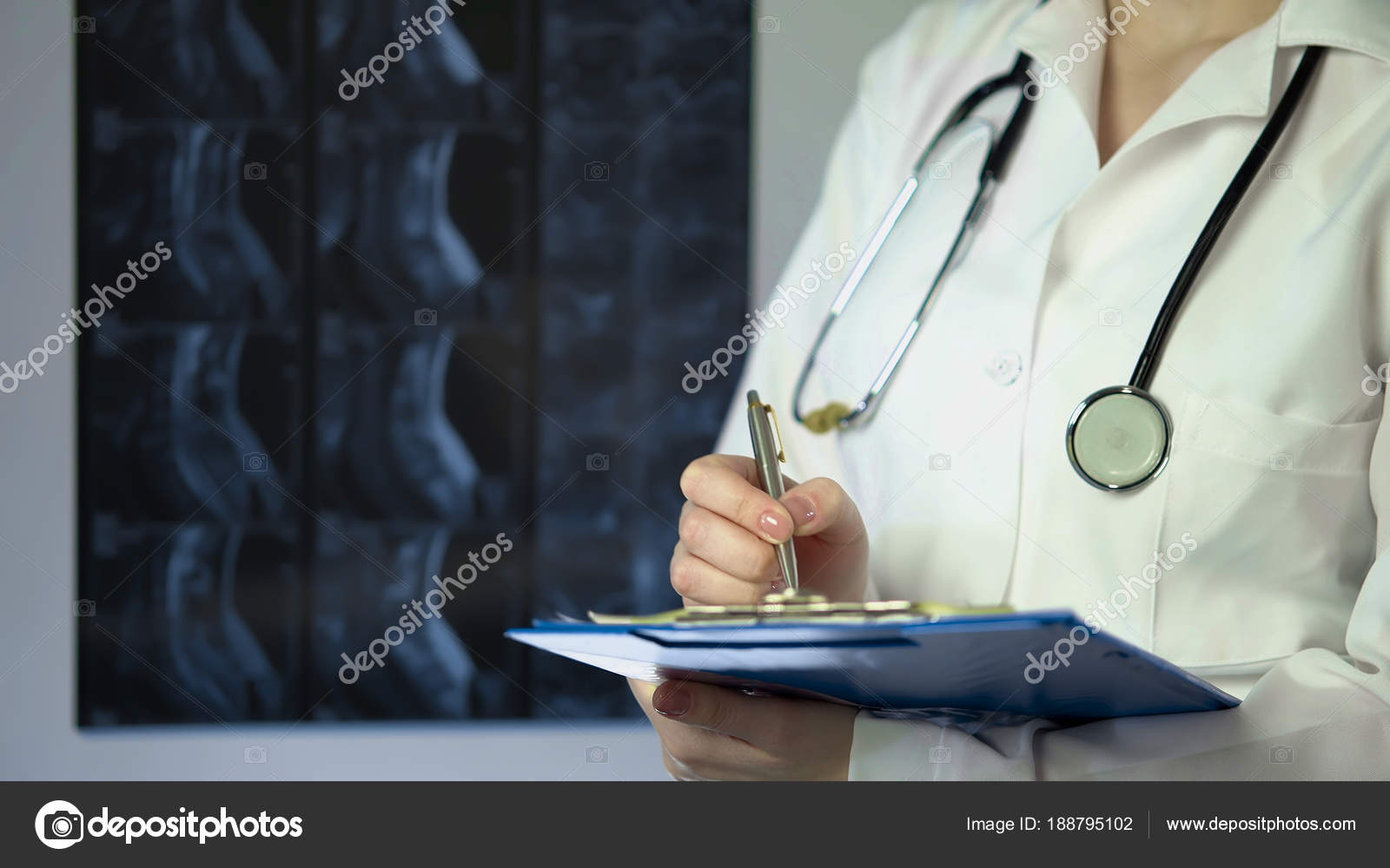 Cirujano anotando el diagnóstico del paciente en las historias clínicas cerca de la radiografía ...