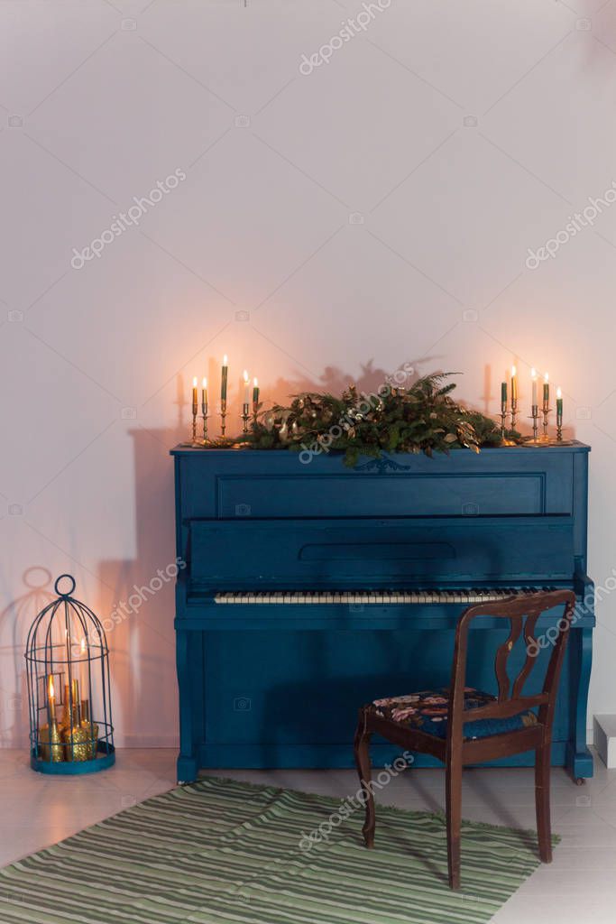 Un viejo piano de color azul, decorado con una larga guirnalda navideña ...