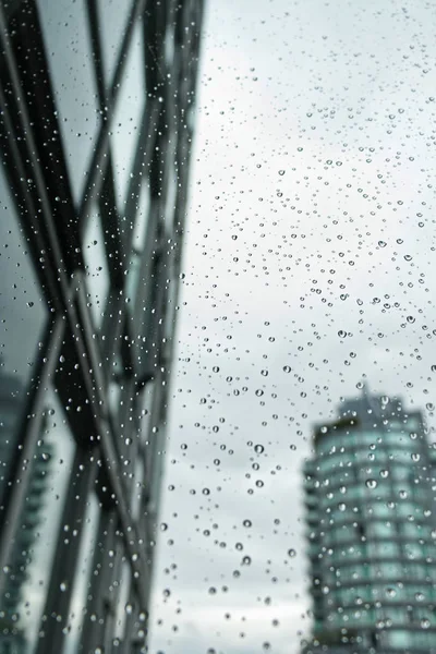 View from the window with water drops on it at rainy Day in Downtown ...