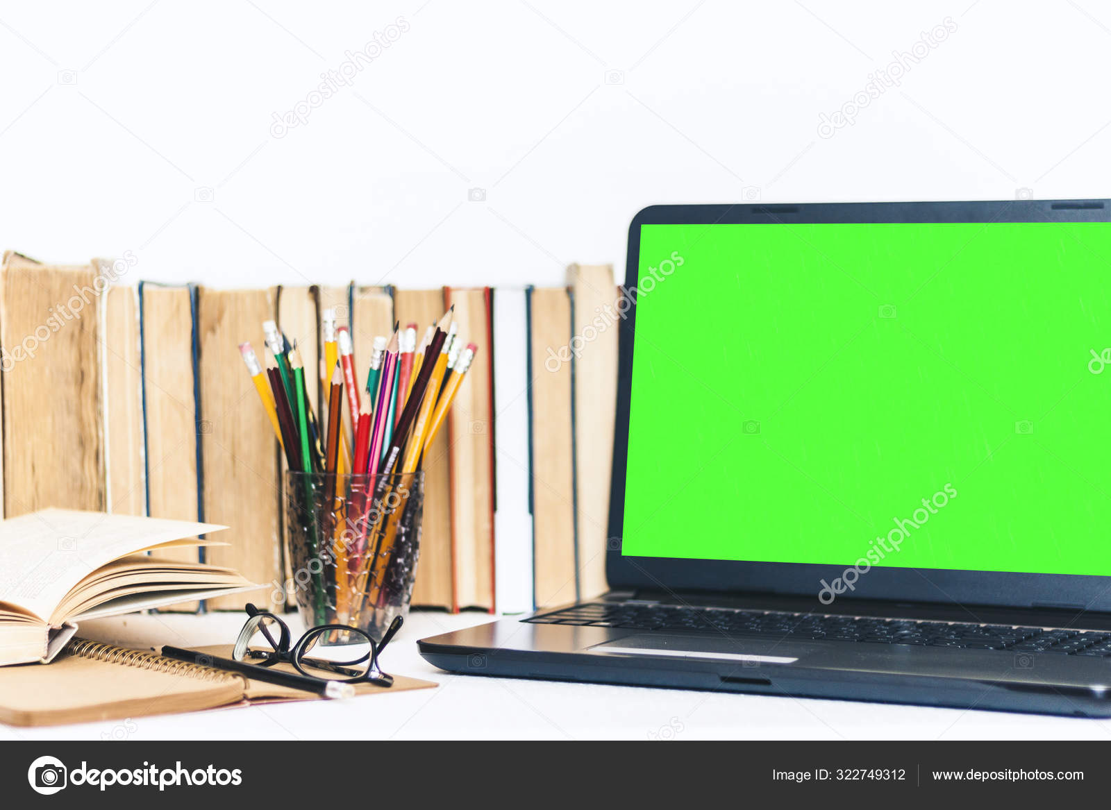 Green screen laptop, pile if books, notebook, smartphone, glasse ...