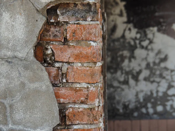 Corner of an old building with crumbling concrete plaster, red ...