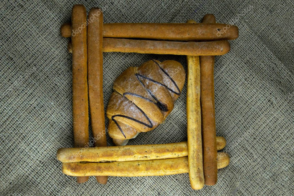 Una pila de palitos de pan o grissini en forma de cuadrado dentro de un ...