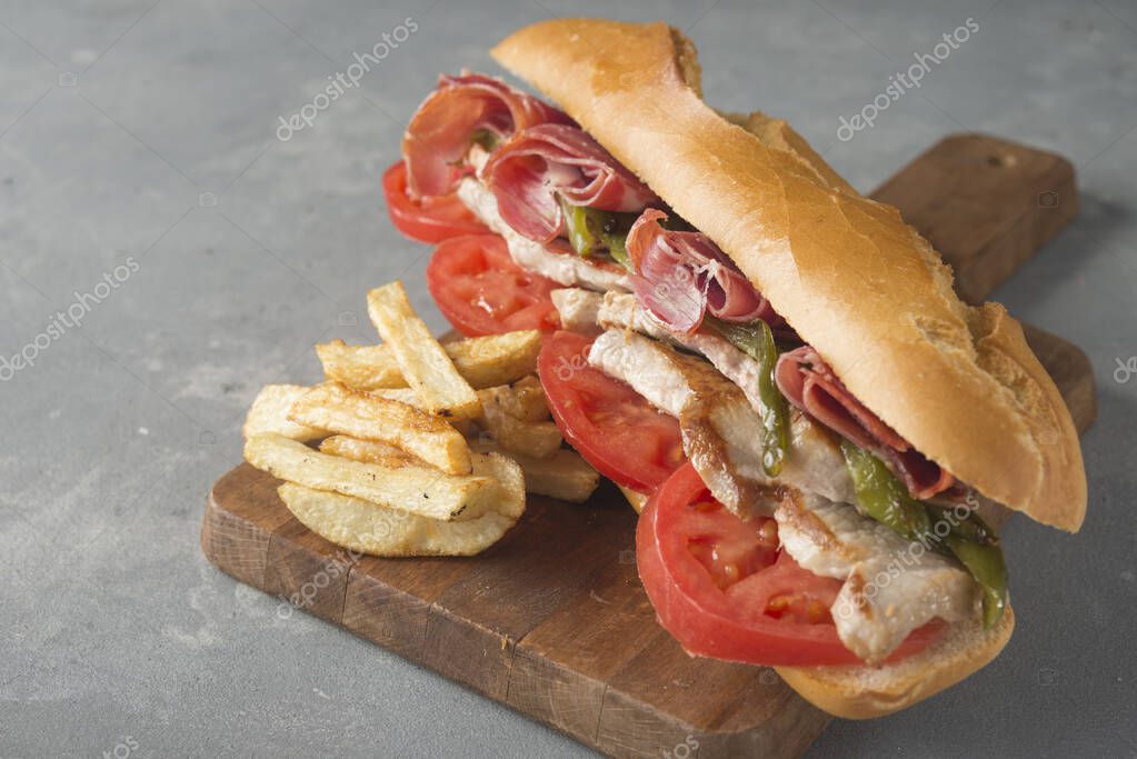 Sandwich Serranito típico de Andalucía con jamón, chile verde y lomo de cerdo a la parrilla 2022