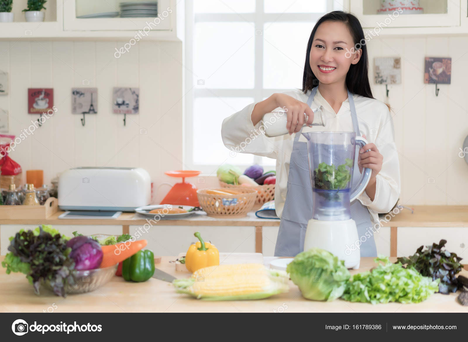 Vegetable smoothie. Asian woman making green smoothies with blen ...