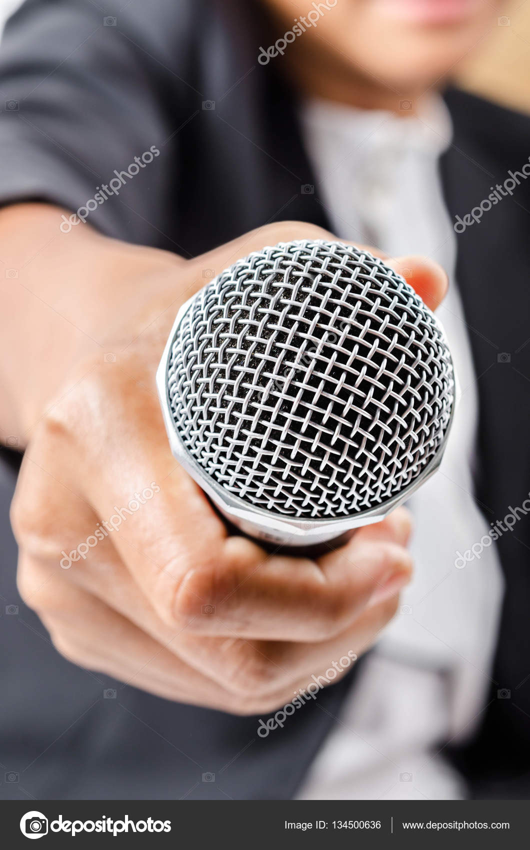 Hand holding a microphone. Stock Photo by ©gamjai 134500636