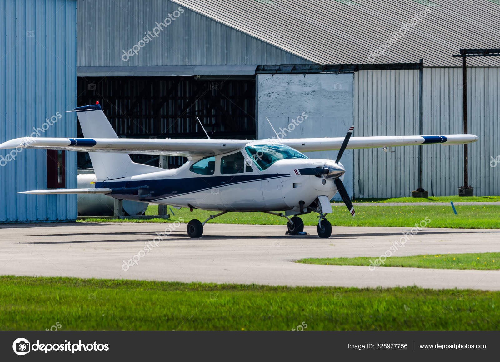 Close-up of a single engine plane in front of a hangar building — Stock ...