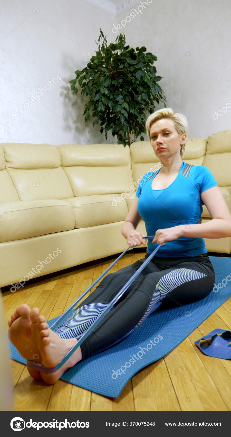 Vertical shot, woman has home sport using stretch tape. — Stock Photo ...
