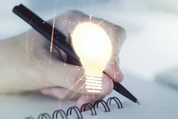Creative light bulb illustration with hand writing in notepad on ...
