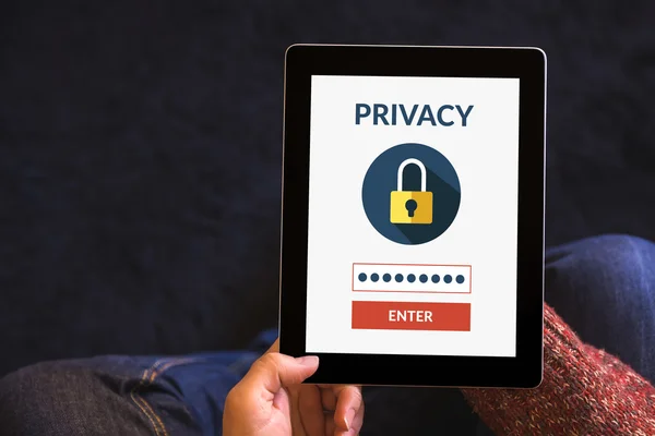 Hands holding tablet computer with online privacy concept on scr ...