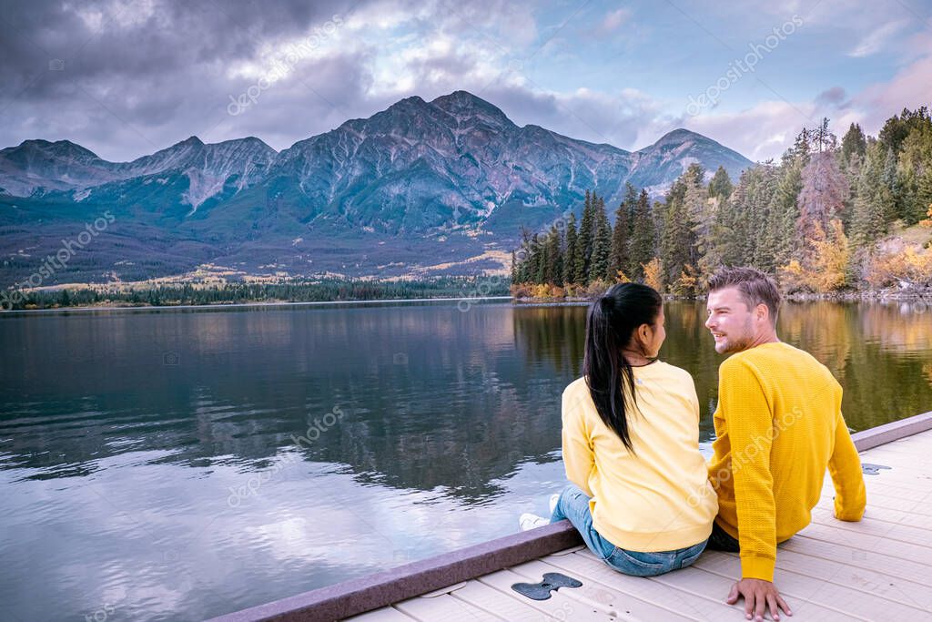pareja por el lago viendo la puesta del sol, Pirámide lago Jasper durante el otoño en Alberta ...