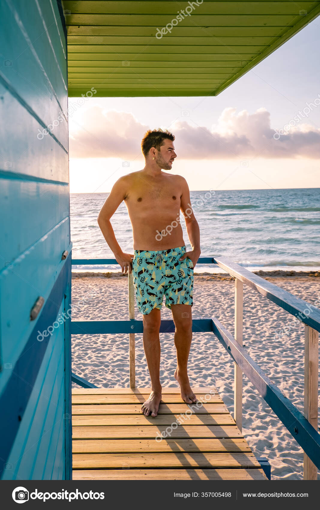 Miami beach Florida, young men on the beach with colorful lifeguard hut ...