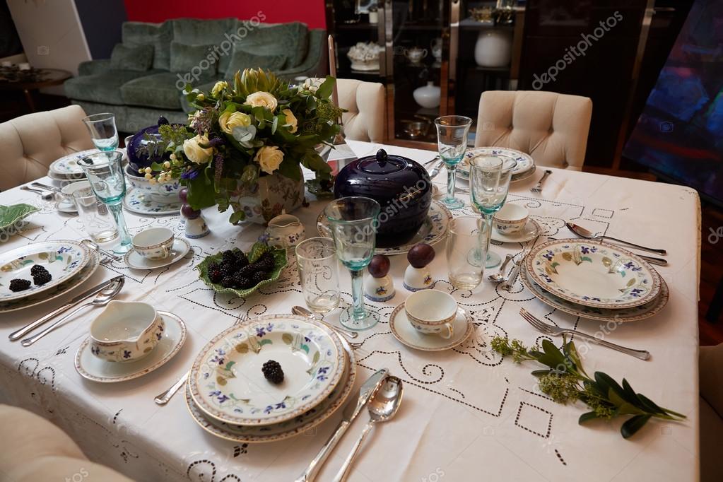 Beautifully decorated table set with flowers, candles, plates and ...