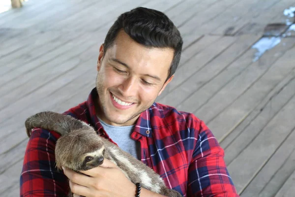 close-up portrait of handsome young man holding adorable sloth - Stock ...