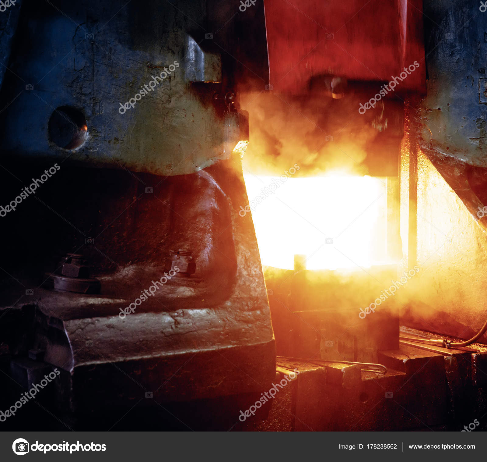 Metal forging, forging shop. hydraulic hammer shapes the red-hot billet ...