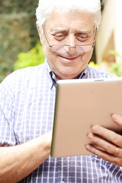Old man using tablet. — Stock Photo © nicomenijes #150221852