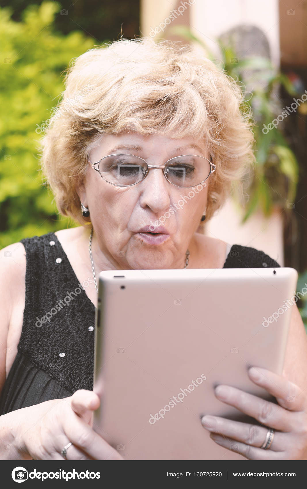 Elderly woman using tablet. — Stock Photo © nicomenijes #160725920