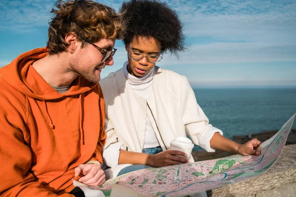 Two travelers with a map. Stock Photo by ©nicomenijes 434344294