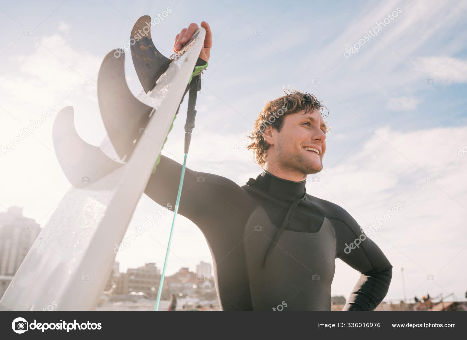 Surfer standing at the beach with surfboard. Stock Photo by ...