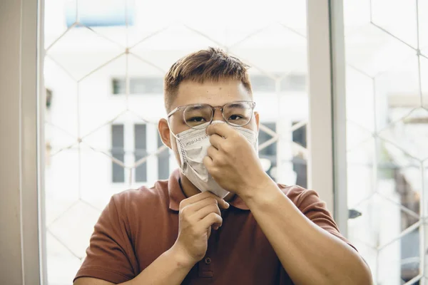 Protection against coronavirus in workplace. Young asian man putting on ...