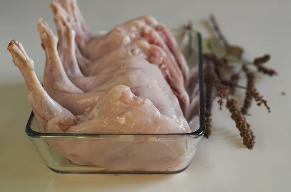 Carcass of raw rabbit meat on a glass baking sheet. Home cooking, cook ...