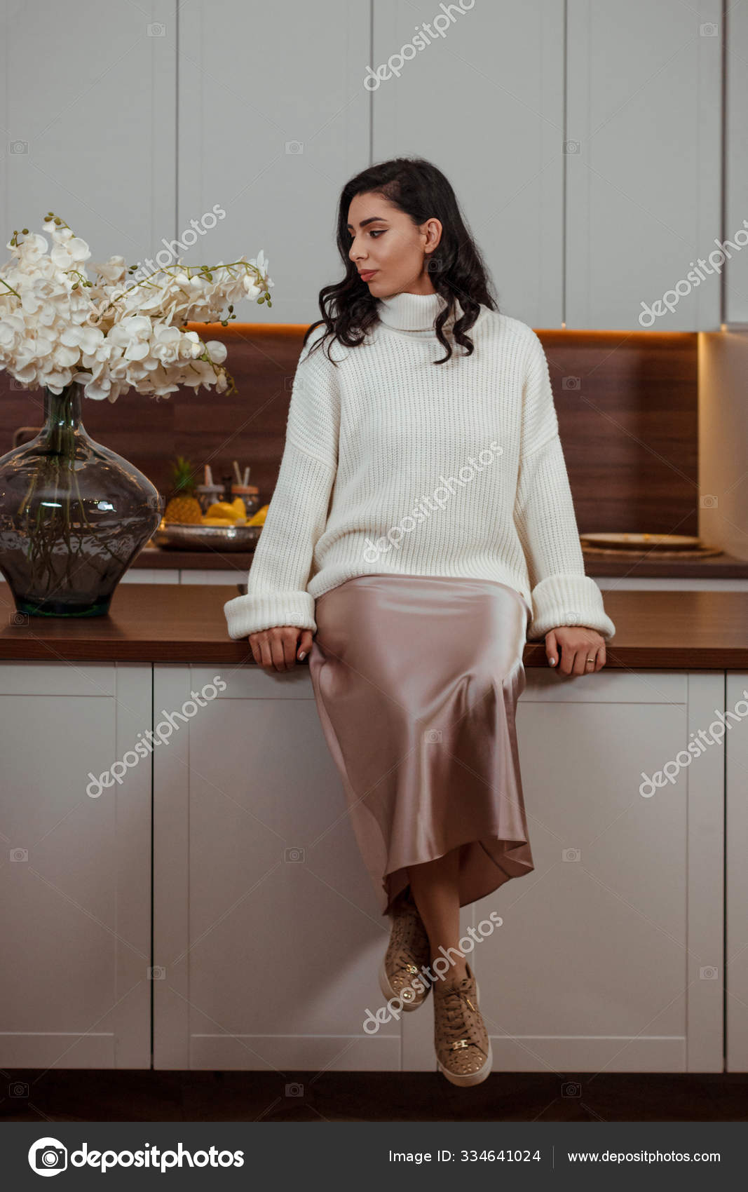 Beautiful young woman sitting on kitchen table Stock Photo by ©cellar ...