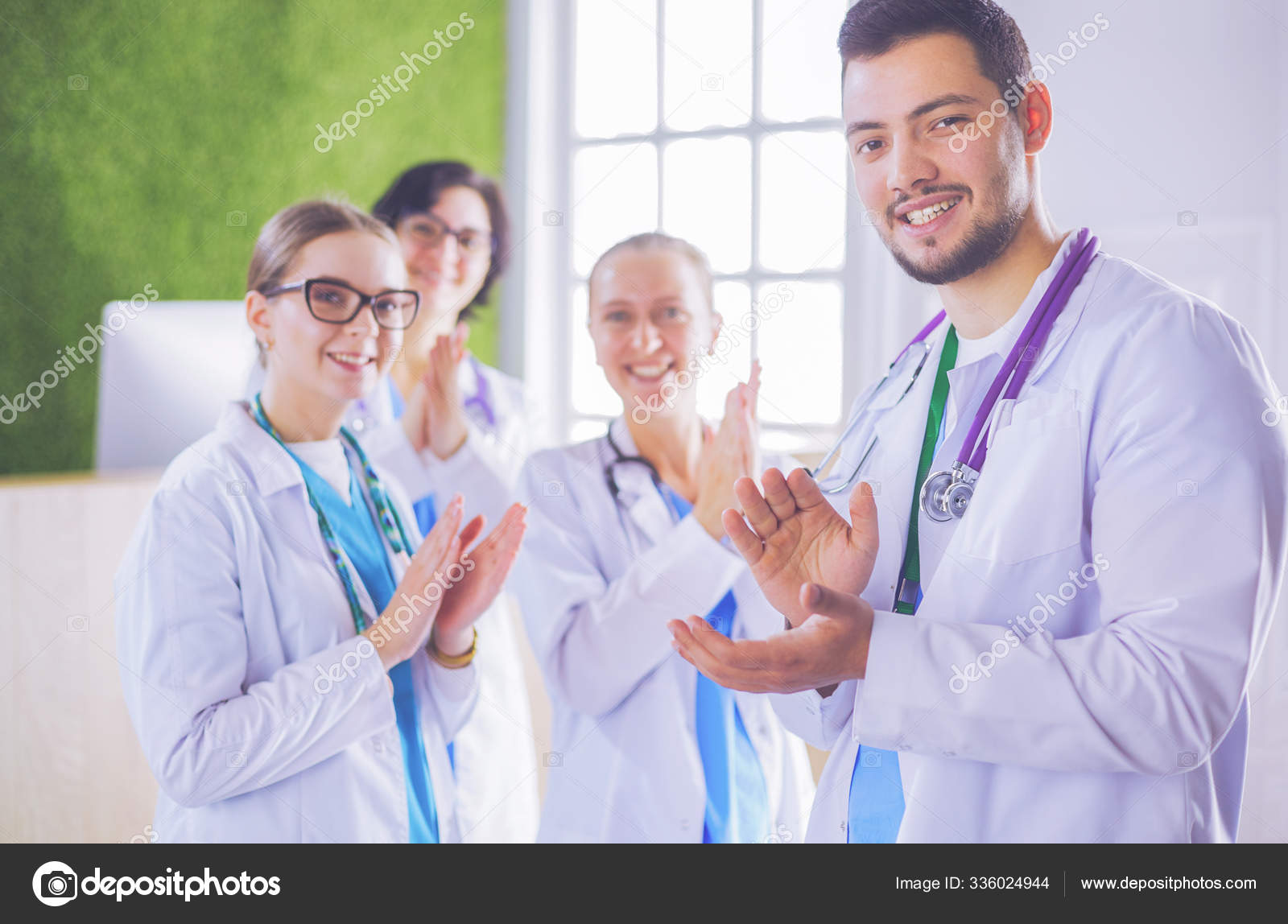 Happy medical team comprising male and female doctors smiling broadly ...