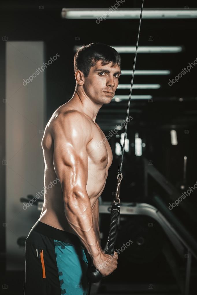 Muscular man working out in gym doing exercises at triceps, strong male naked torso abs Stock ...