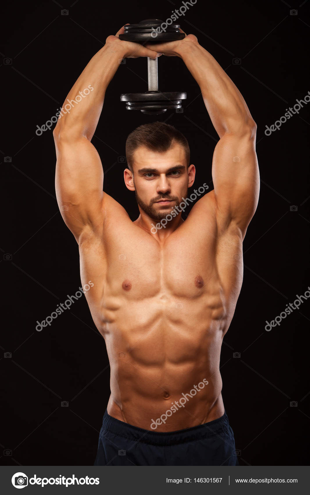 Strong man making exercises on triceps with a dumbbell. Close up shot ...