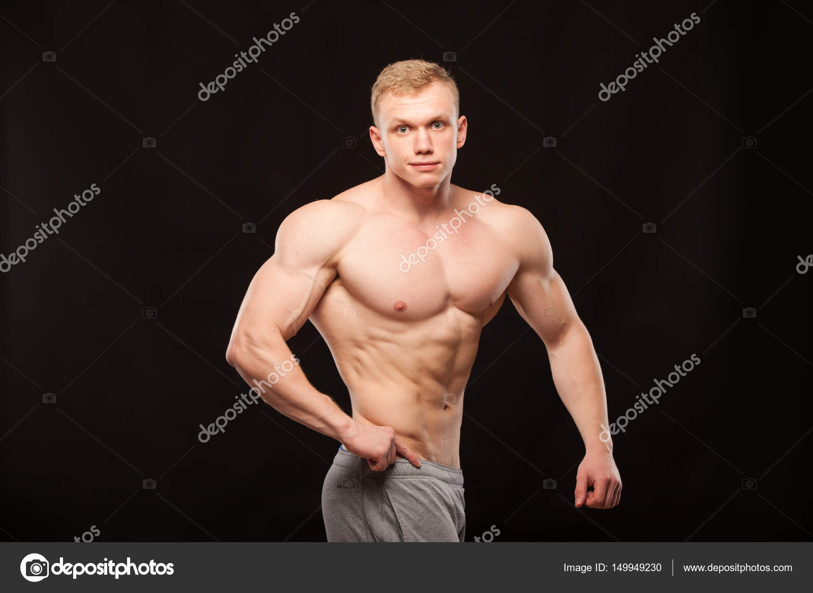 Athletic handsome man fitness-model is showing six pack abs and oblique ...