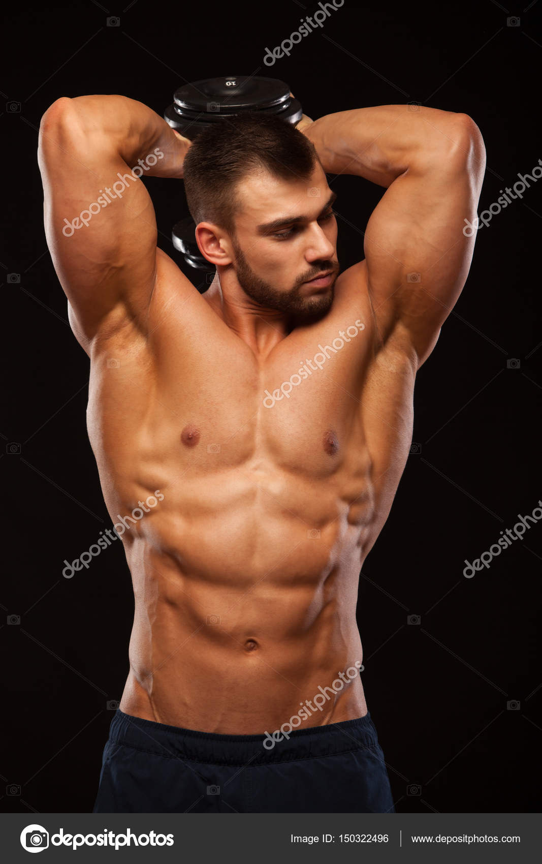 Strong man making exercises on triceps with a dumbbell. Close up shot ...