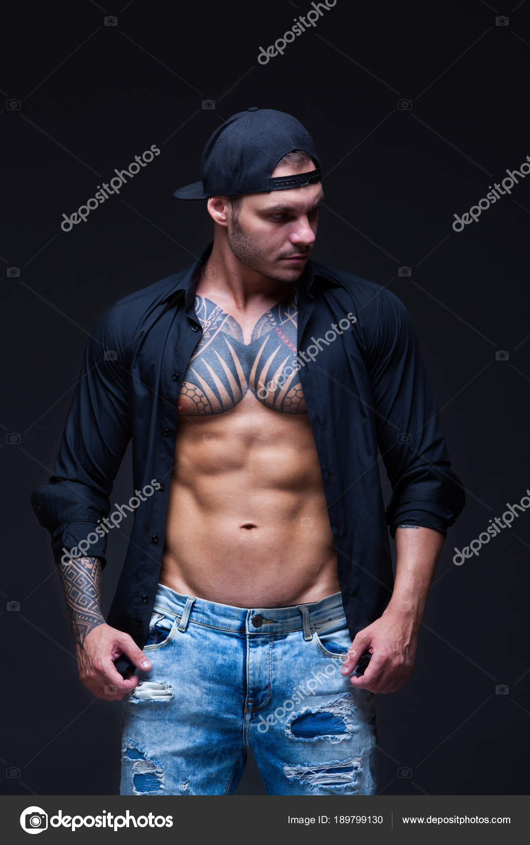 The man dressed blue jeans, black shirt and black baseball cap with ...