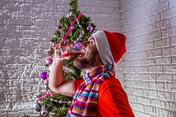 Angry and aggressive Santa stands near a Christmas tree and breaks the ...