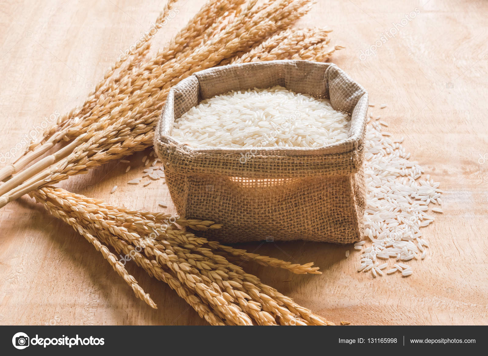 Raw rice grain and dry rice plant on wooden table background. Stock ...