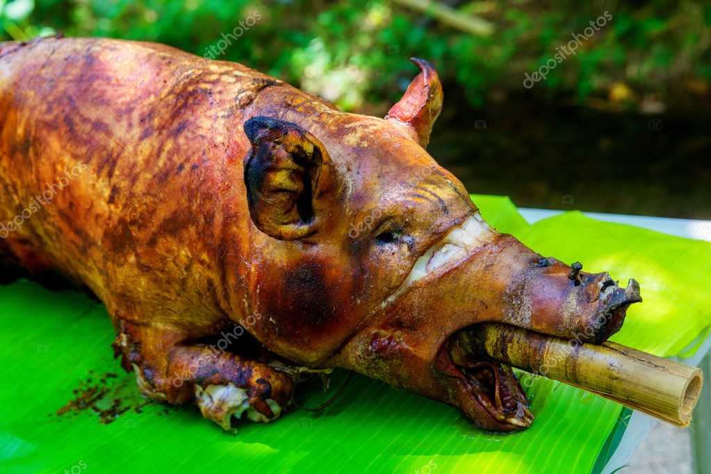Fire-roasted suckling pig served on banana leaves. Filipino food ...