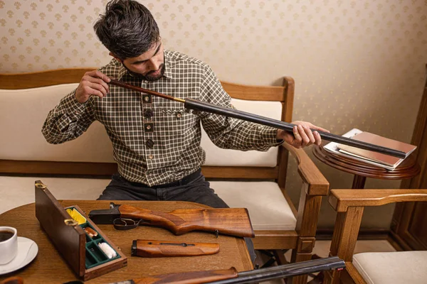 Handsome guy looking at rifle in hands Stock Photo by ©romanchazov27 ...