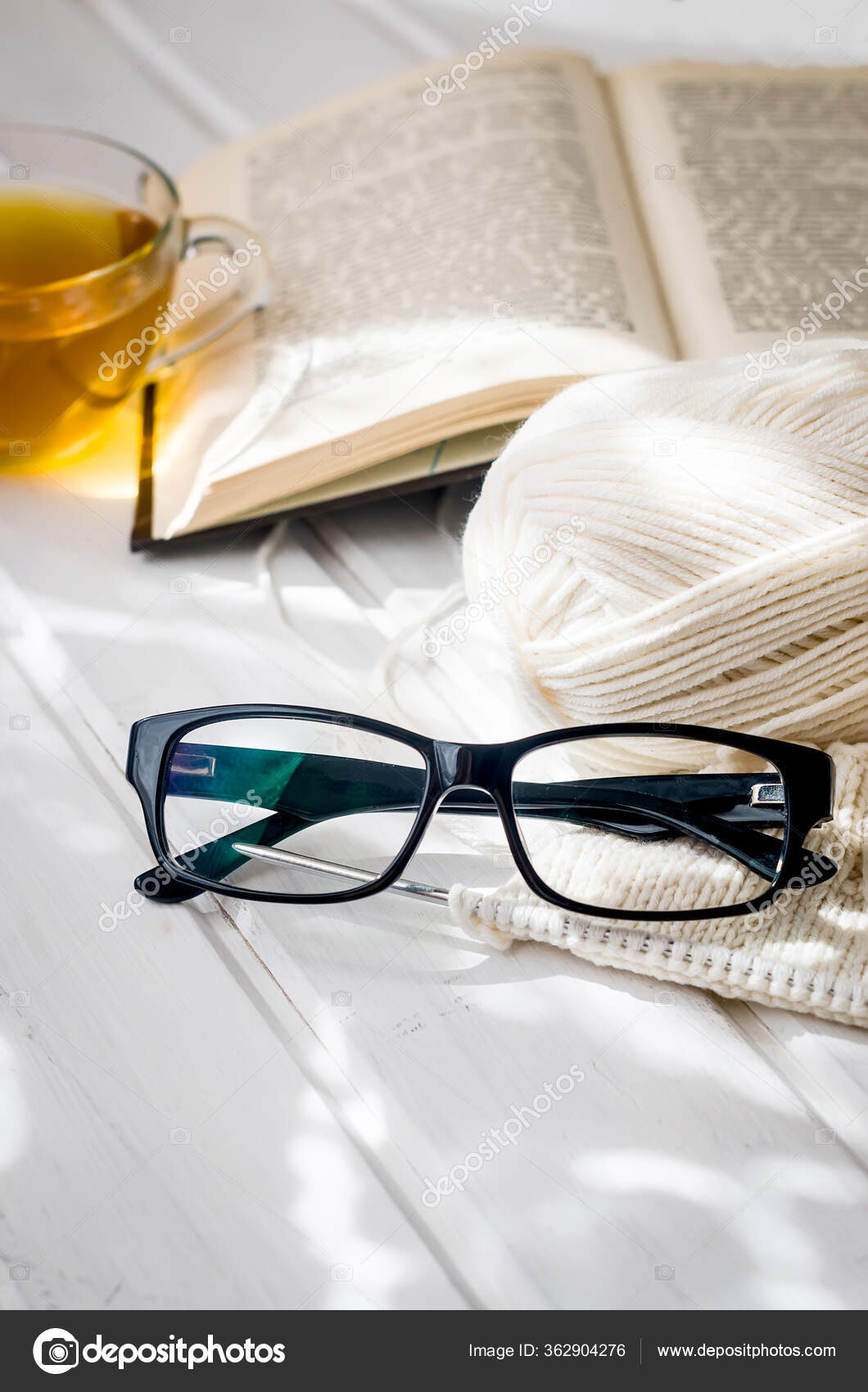 Eyeglasses, open book, Cup of tea and Knitting threads — Stock Photo ...