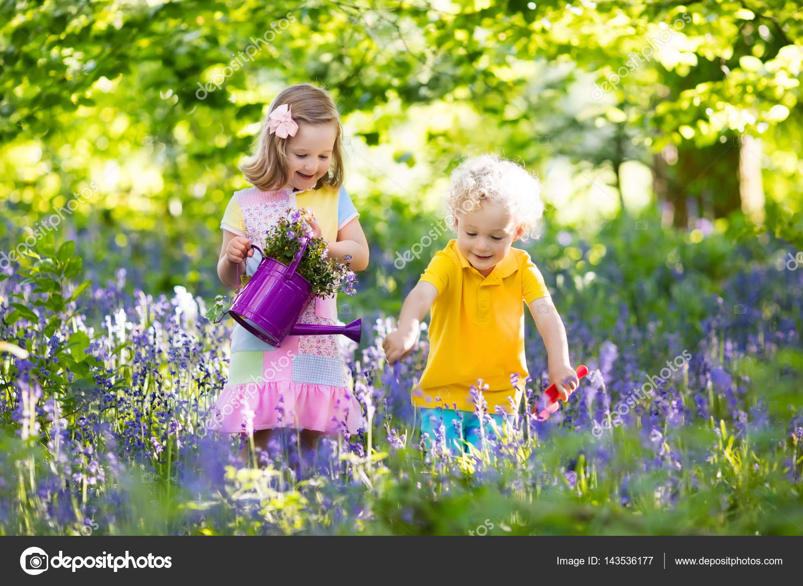 Kids playing in blooming garden with bluebell flowers — Stock Photo ...