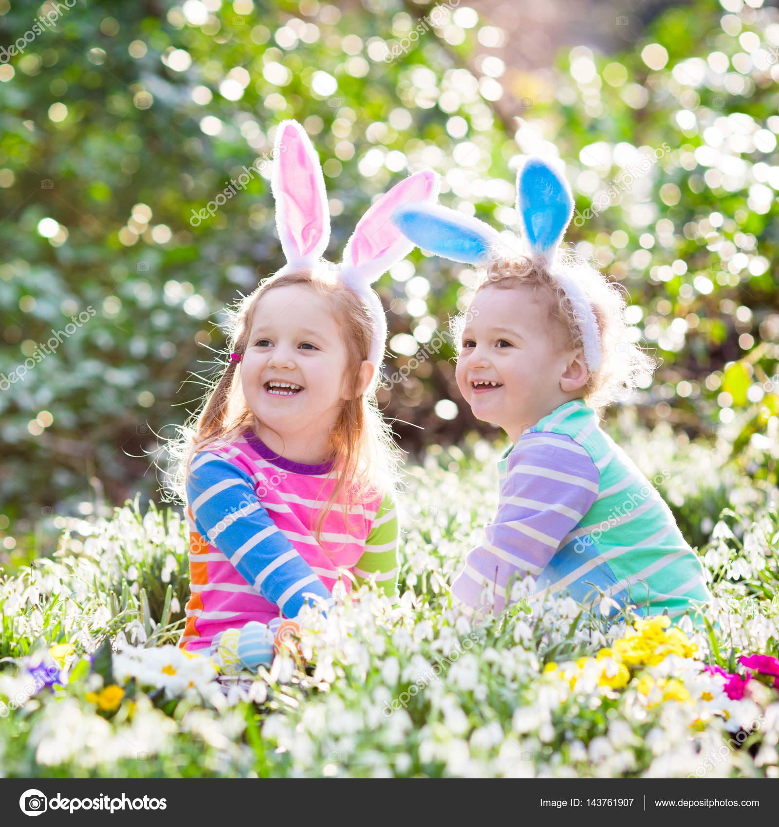 Kids on Easter egg hunt in blooming spring garden Stock Photo by ...